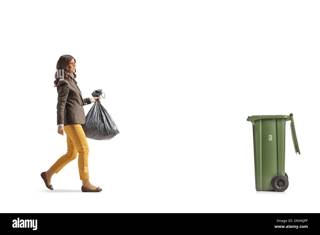 Full length profile shot of a young woman in formal clothes carrying a ...
