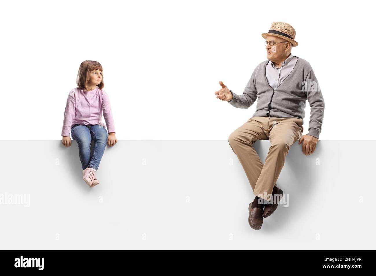 Grandfather talking to a little girl seated on a blank panel isolated ...