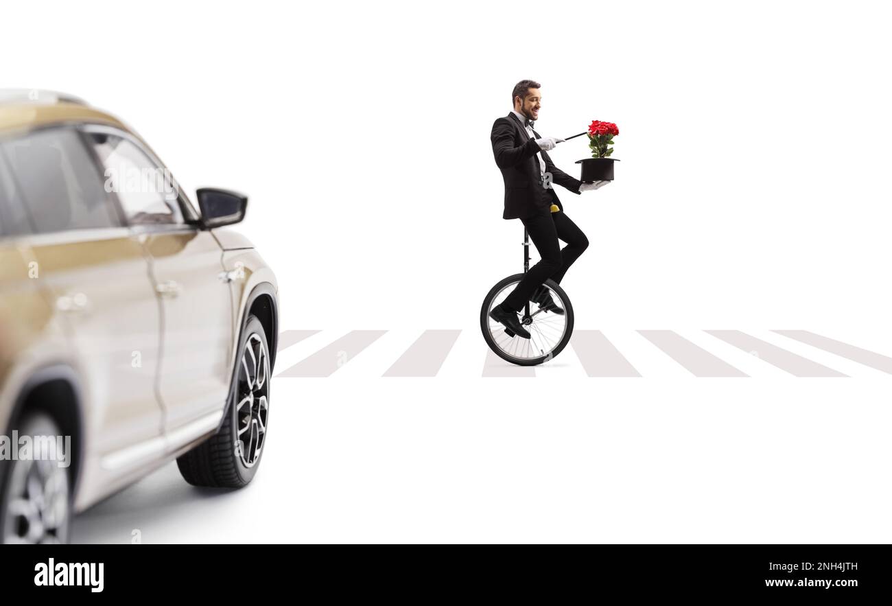 Man riding a mono cycle on a pedestrian crossing and performing a magic ...