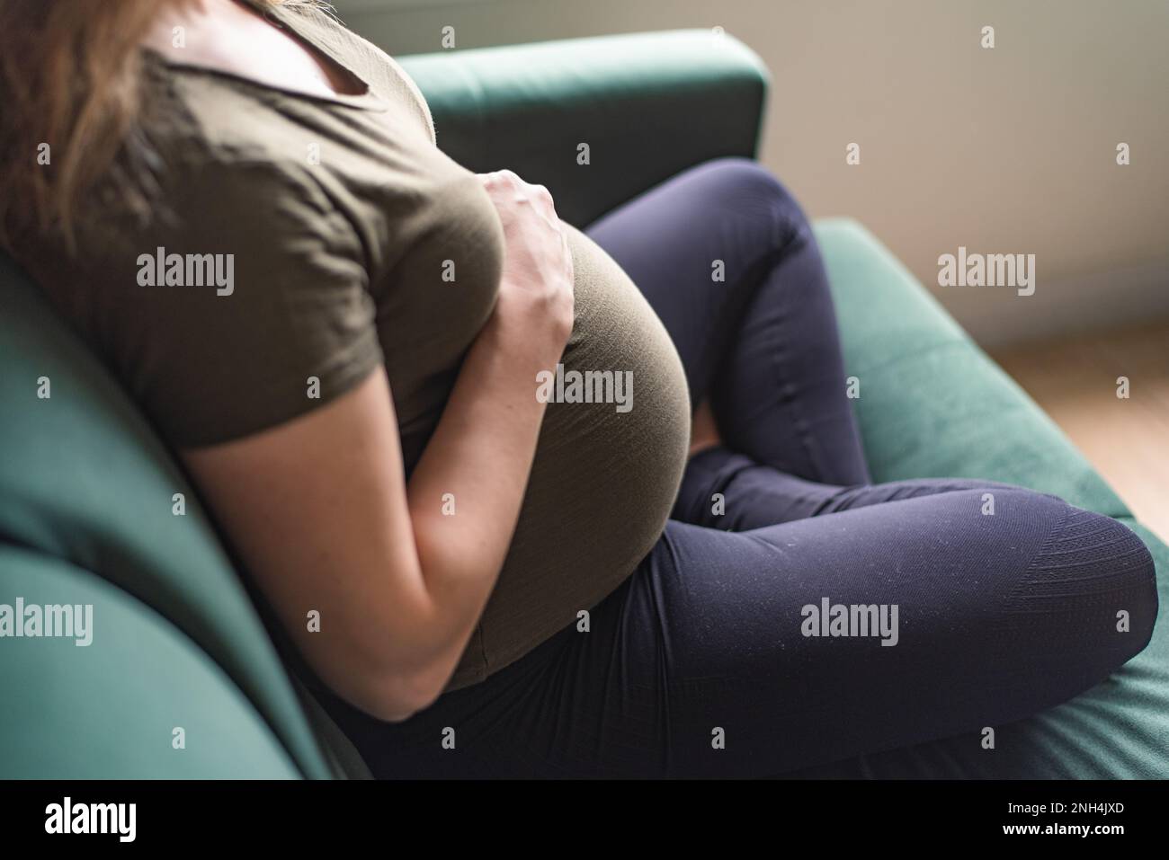 Pregnant woman sitting on sofa Stock Photo - Alamy