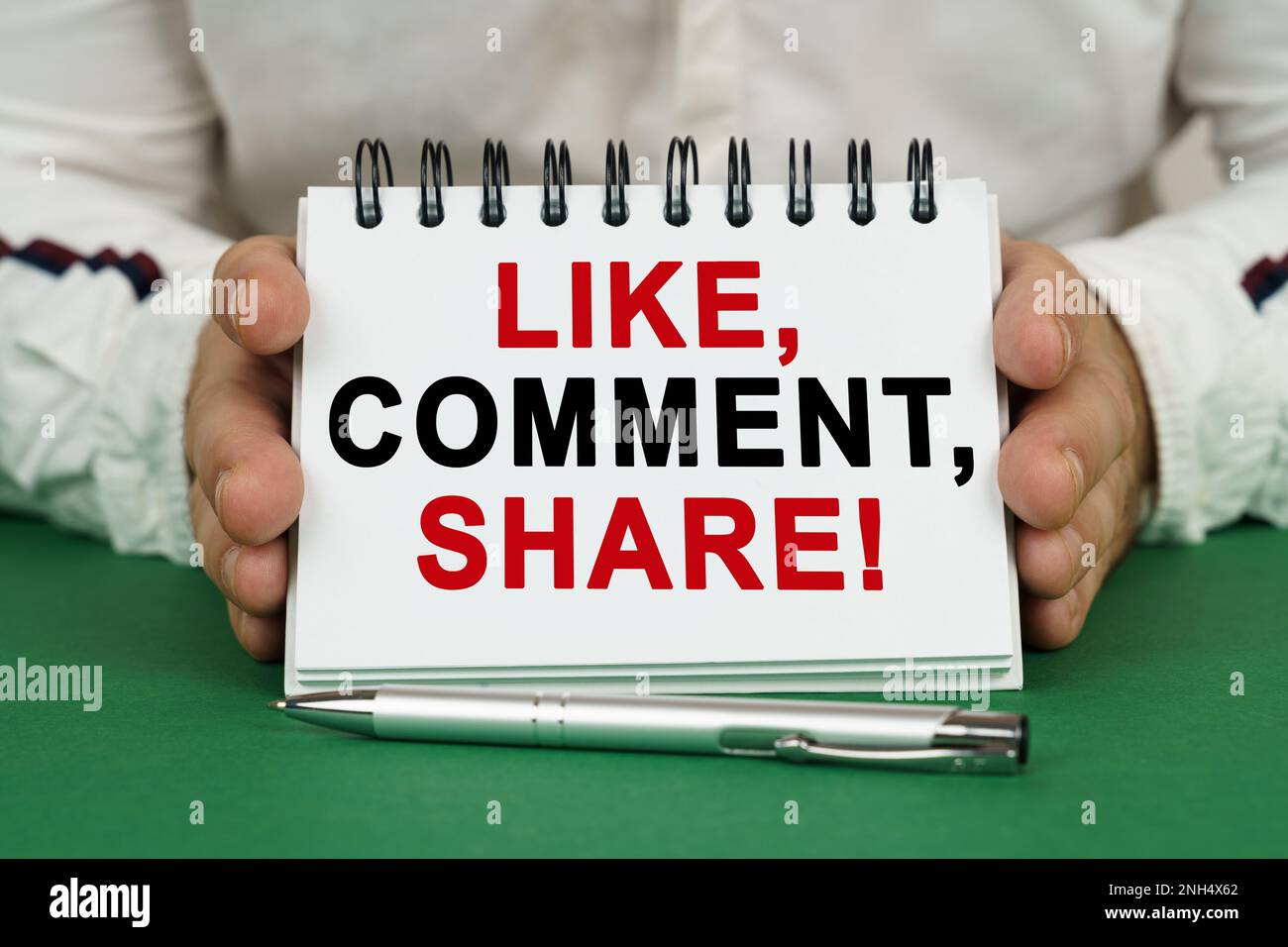A man holds a notepad in his hands with the inscription - Like, comment ...