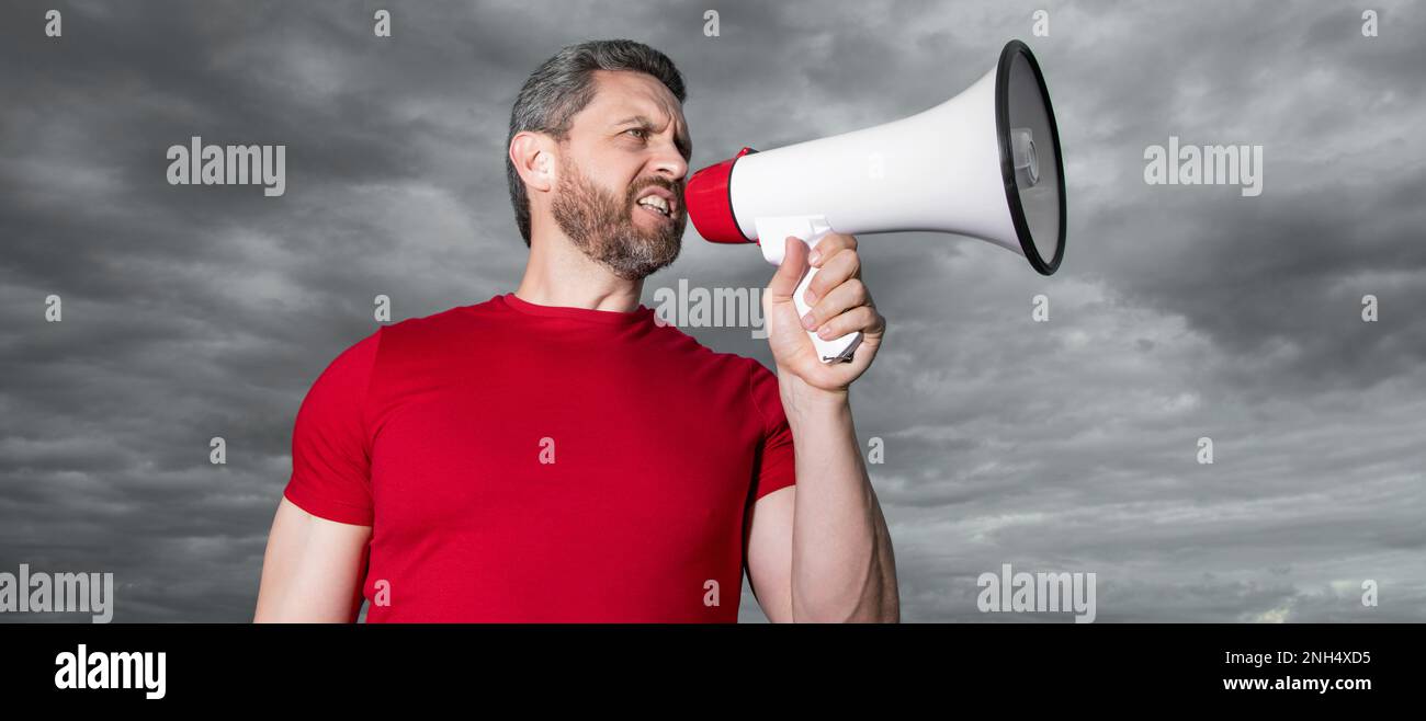 man in red shirt shout in loudspeaker on sky background. advertisement ...