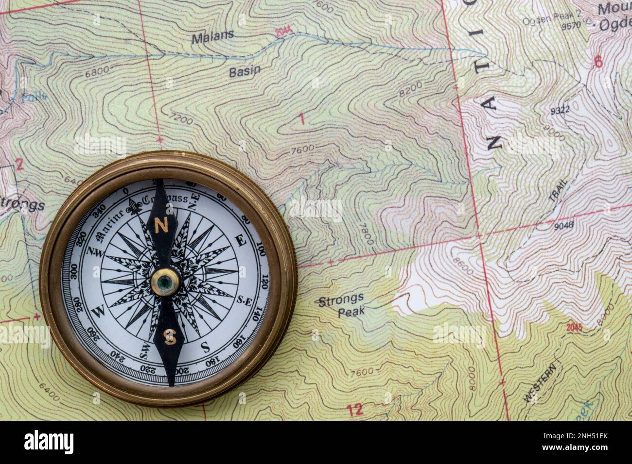 Topographical map showing contour lines with classic compass laid on ...