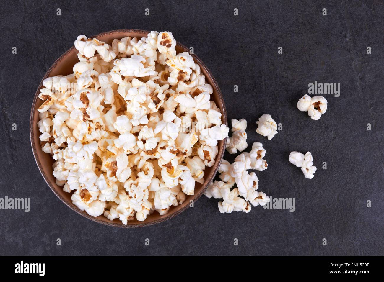 Popcorn in bowl food on black stone background Stock Photo - Alamy