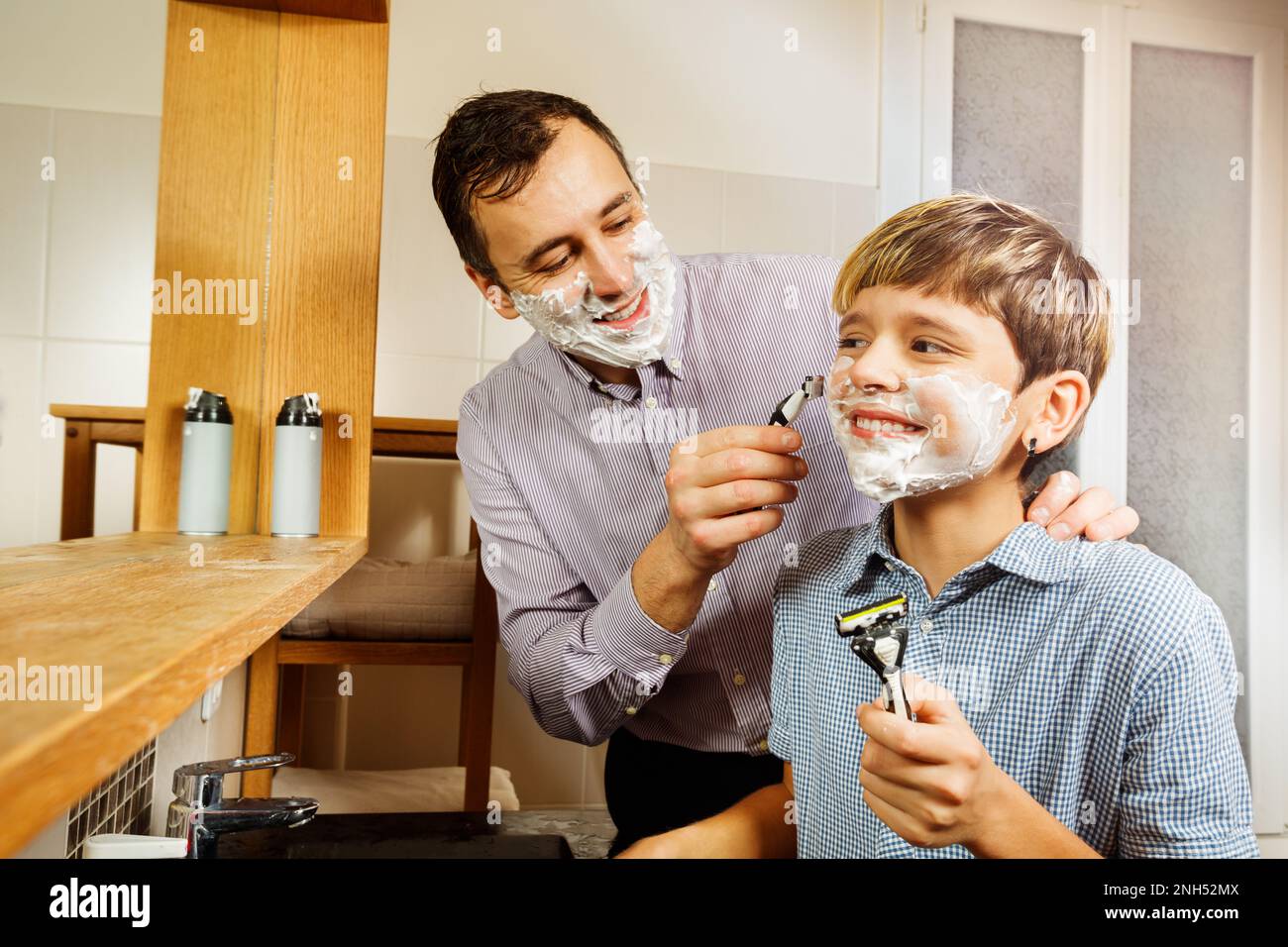 Dad shows son how to shave with razor at bathroom Stock Photo - Alamy