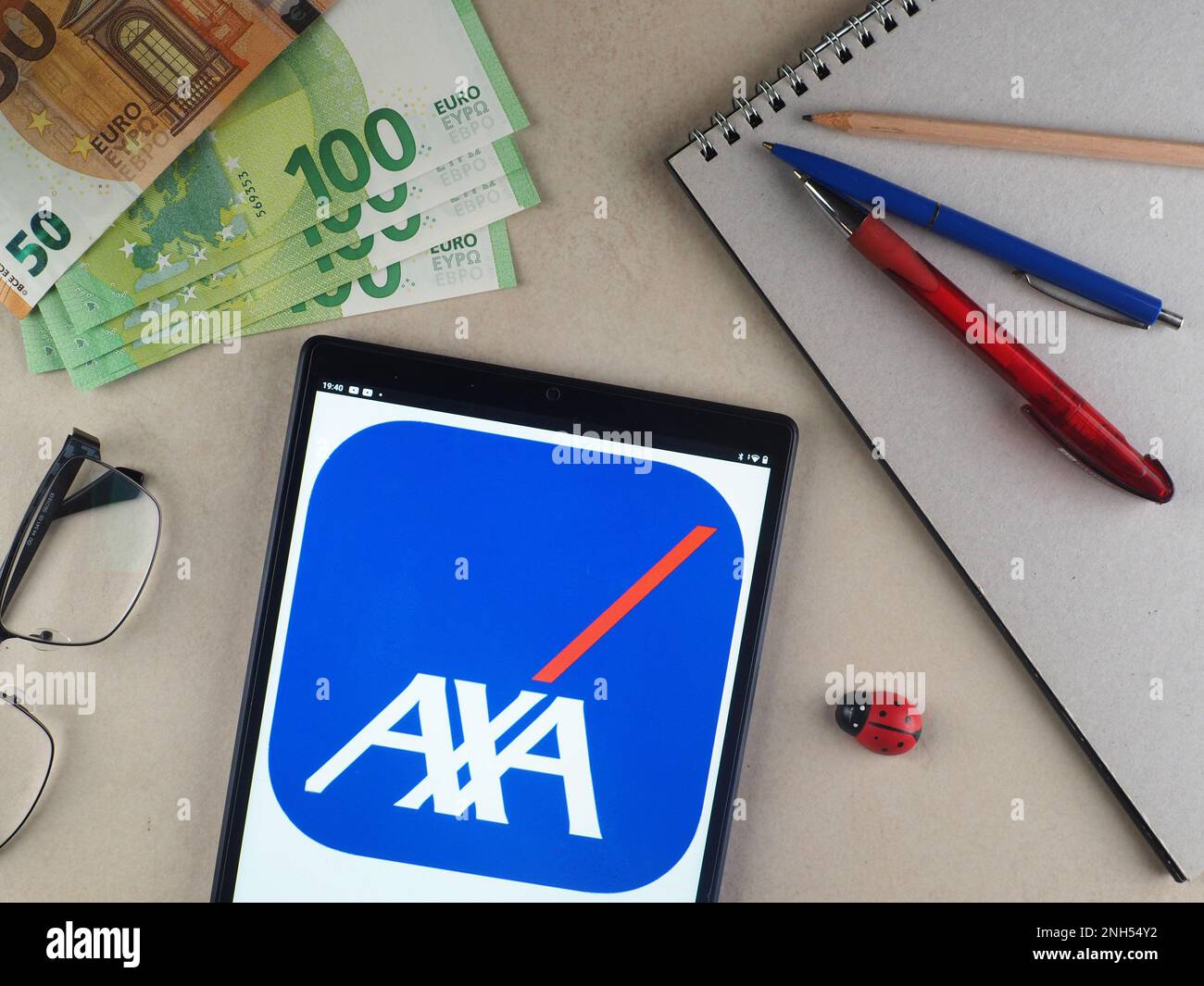 In this photo illustration, AXA Company logo seen displayed on a tablet ...