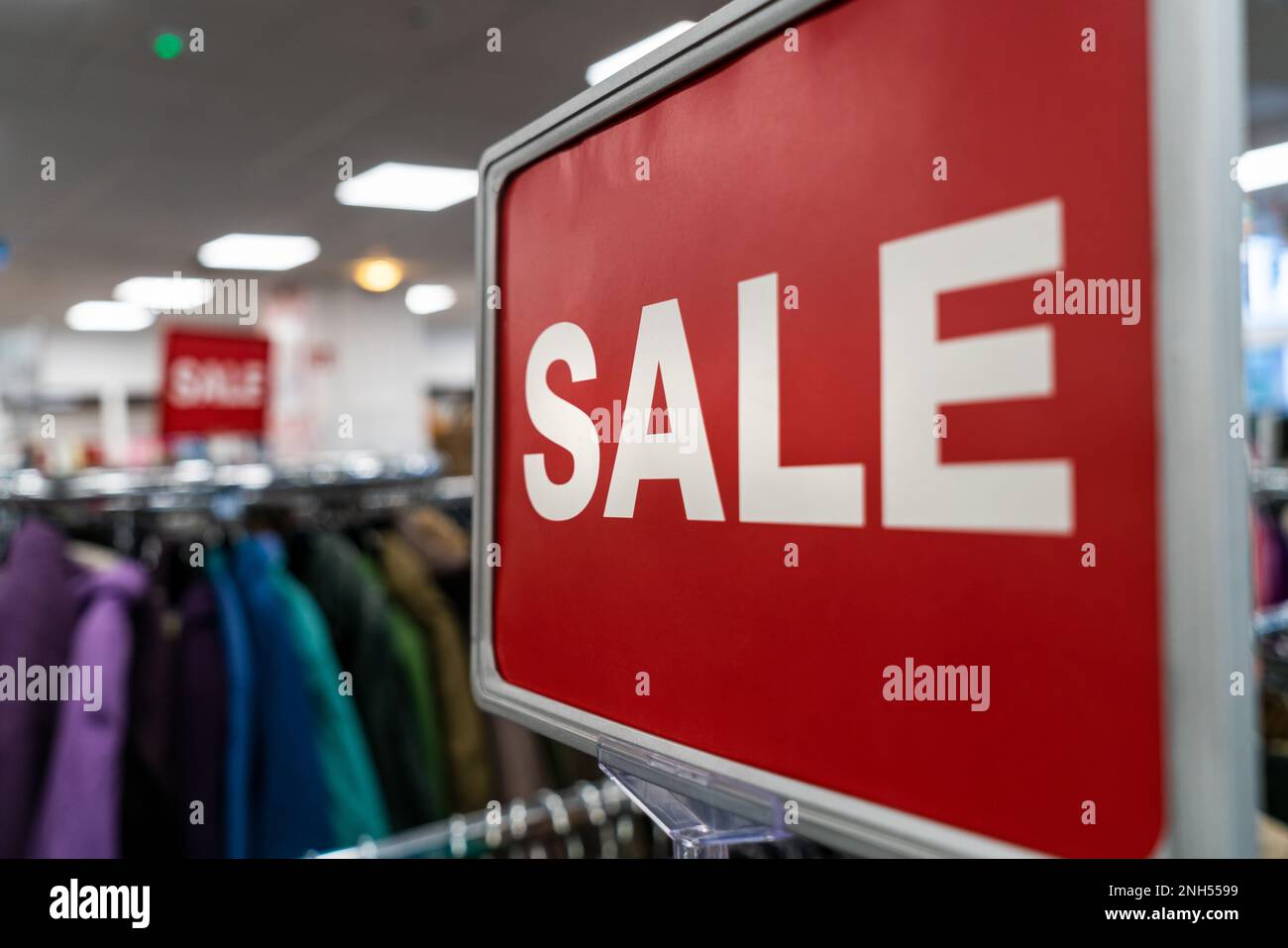 Red sale sign on rail of clothes in a high street shop or store Stock ...