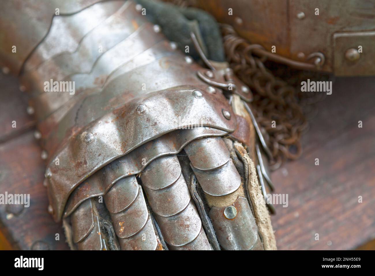 Close-up on a gauntlet on the top of a wood chest next to a shield the ...