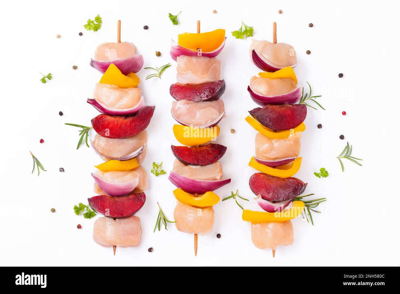 Raw chicken meat skewers with vegetables,plums,yellow pepper,onions ...