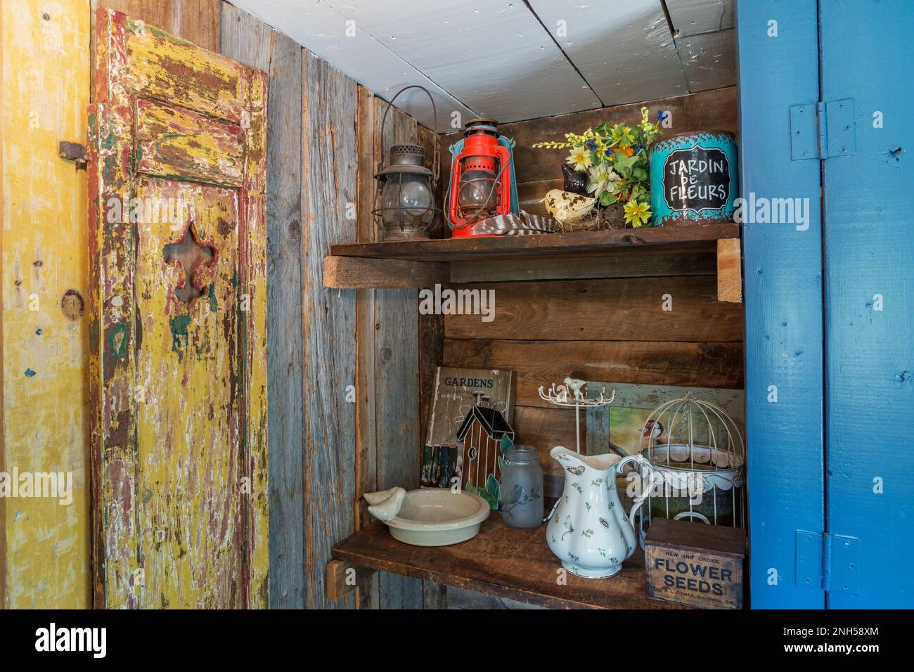 Vintage objects including antique oil lamps on shelves in extension ...