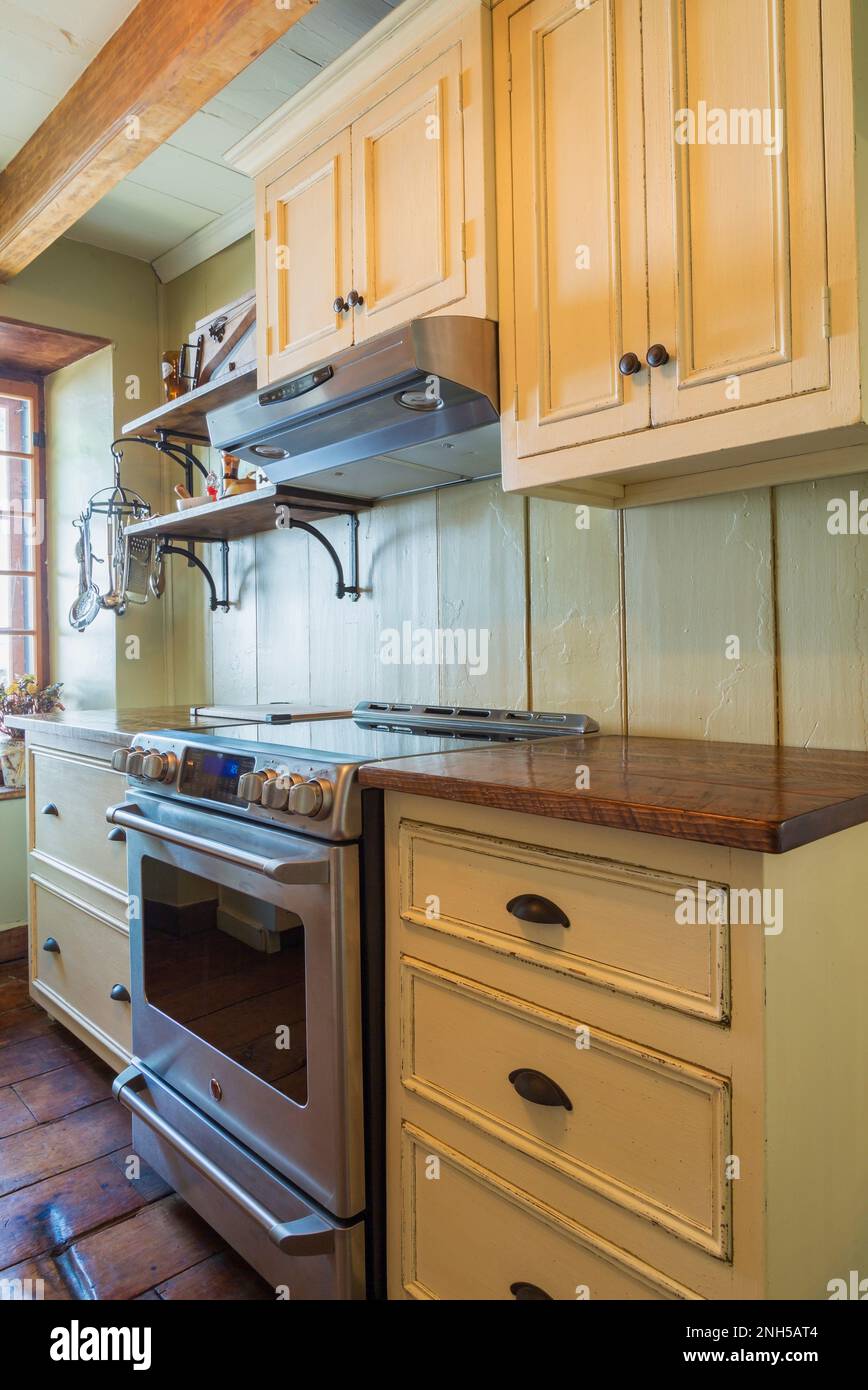 Antique white painted cabinets and stained wooden countertop in kitchen ...