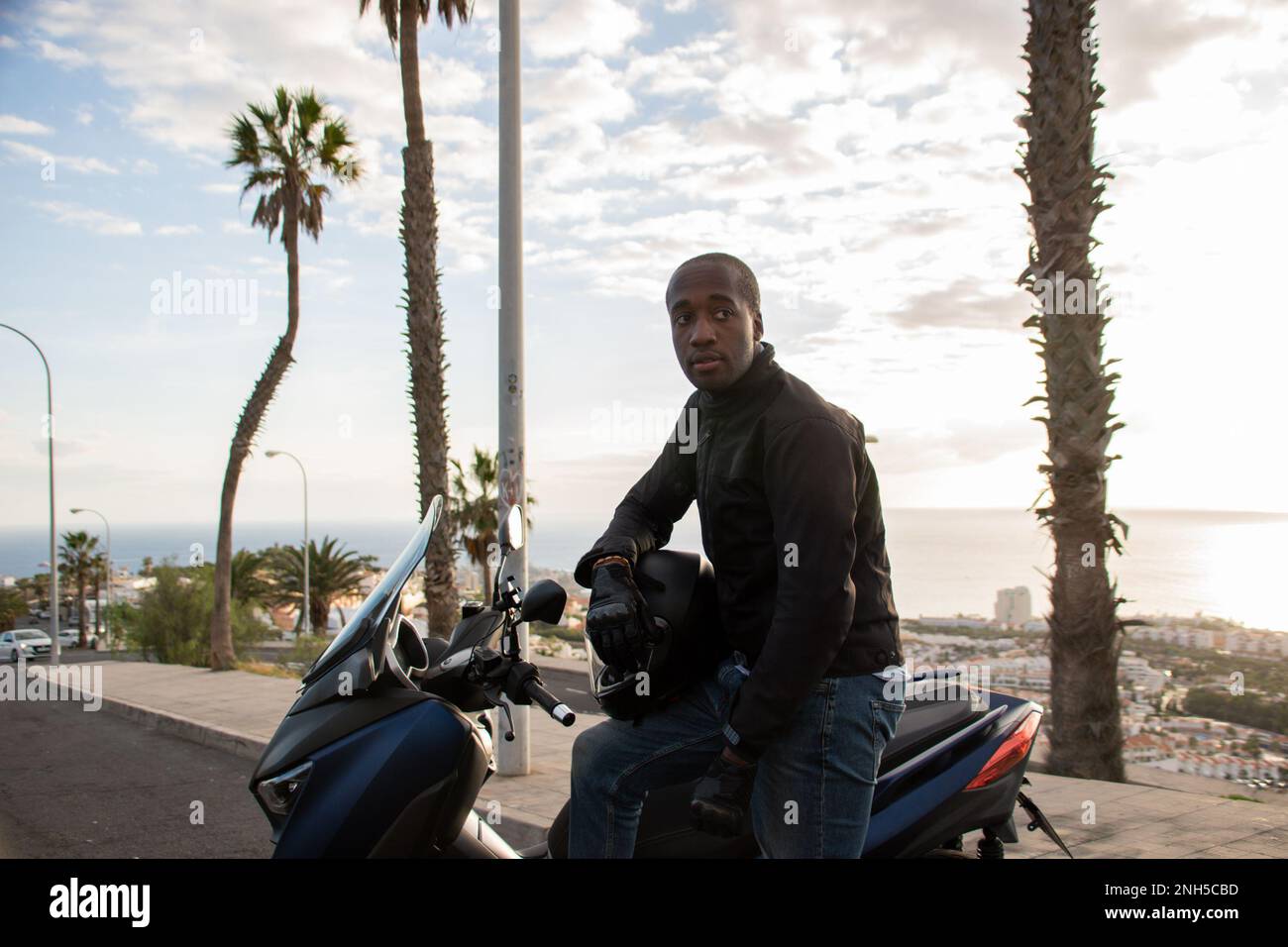 African american biker sitting on his scooter and looking away. He ...