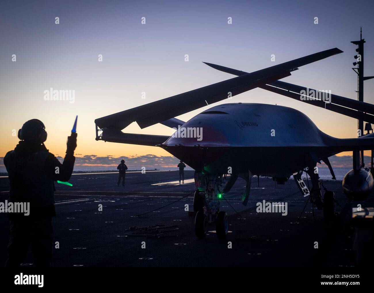 A Boeing unmanned MQ-25 aircraft is given operating directions on the flight deck aboard the ...
