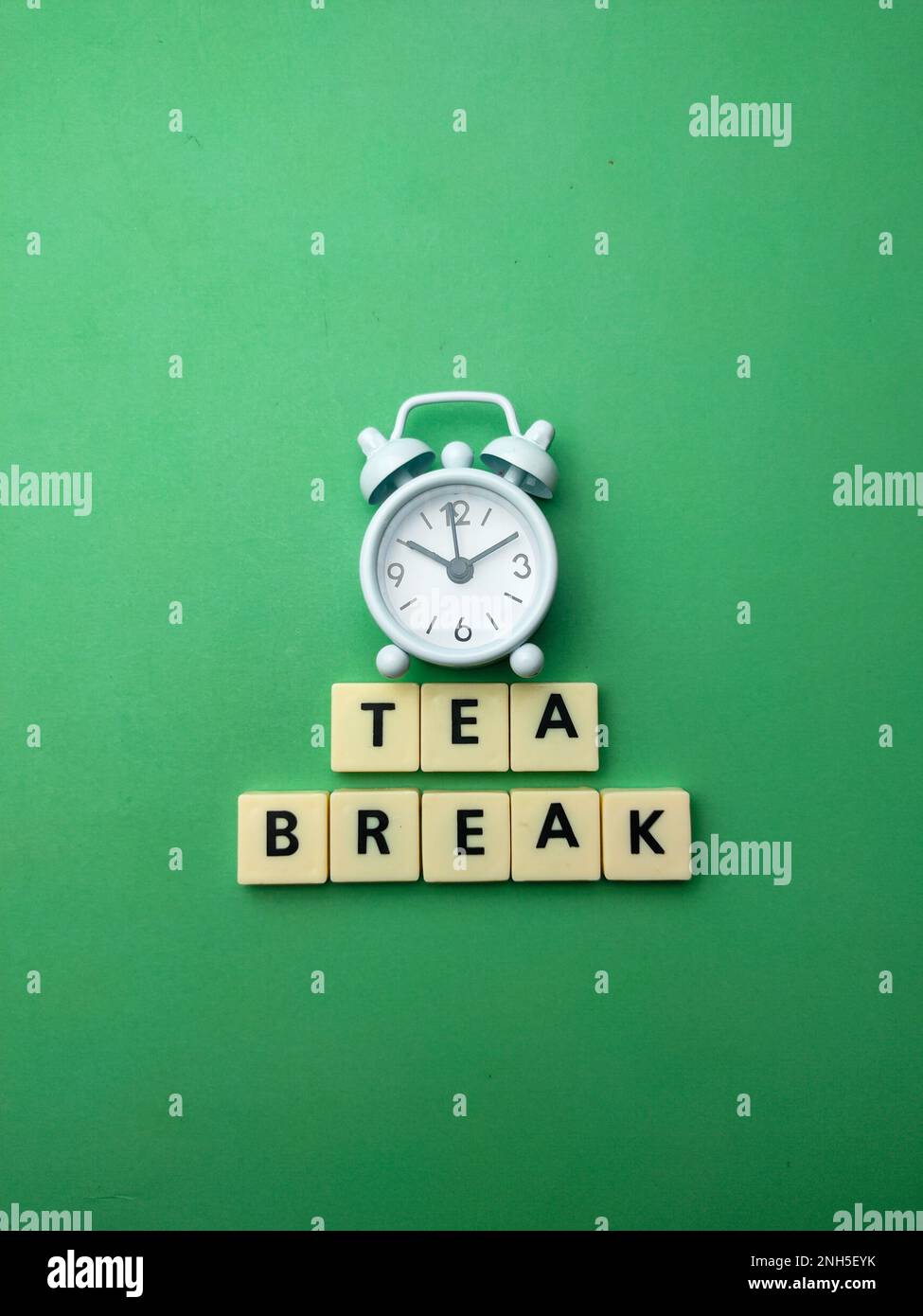 White alarm clock with the word TEA BREAK on a green background Stock ...