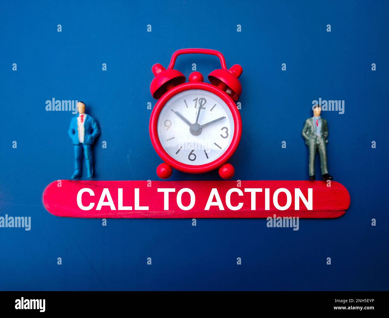 Miniature people and alarm clock with the word call to action. Business ...