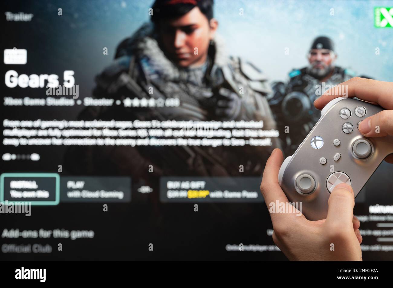 New york, USA - February 20, 2023: Man play Gears game on computer console with xbox joystick in ...