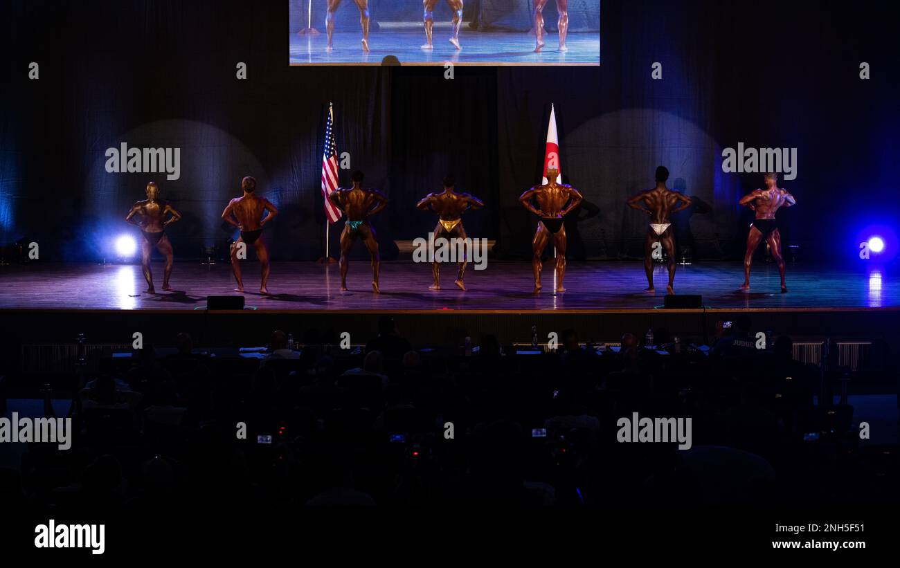 Competitors perform a rear-lat-spread pose at the Far East Bodybuilding ...