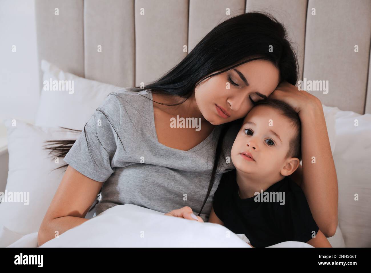 Depressed single mother with child in bed at home Stock Photo - Alamy