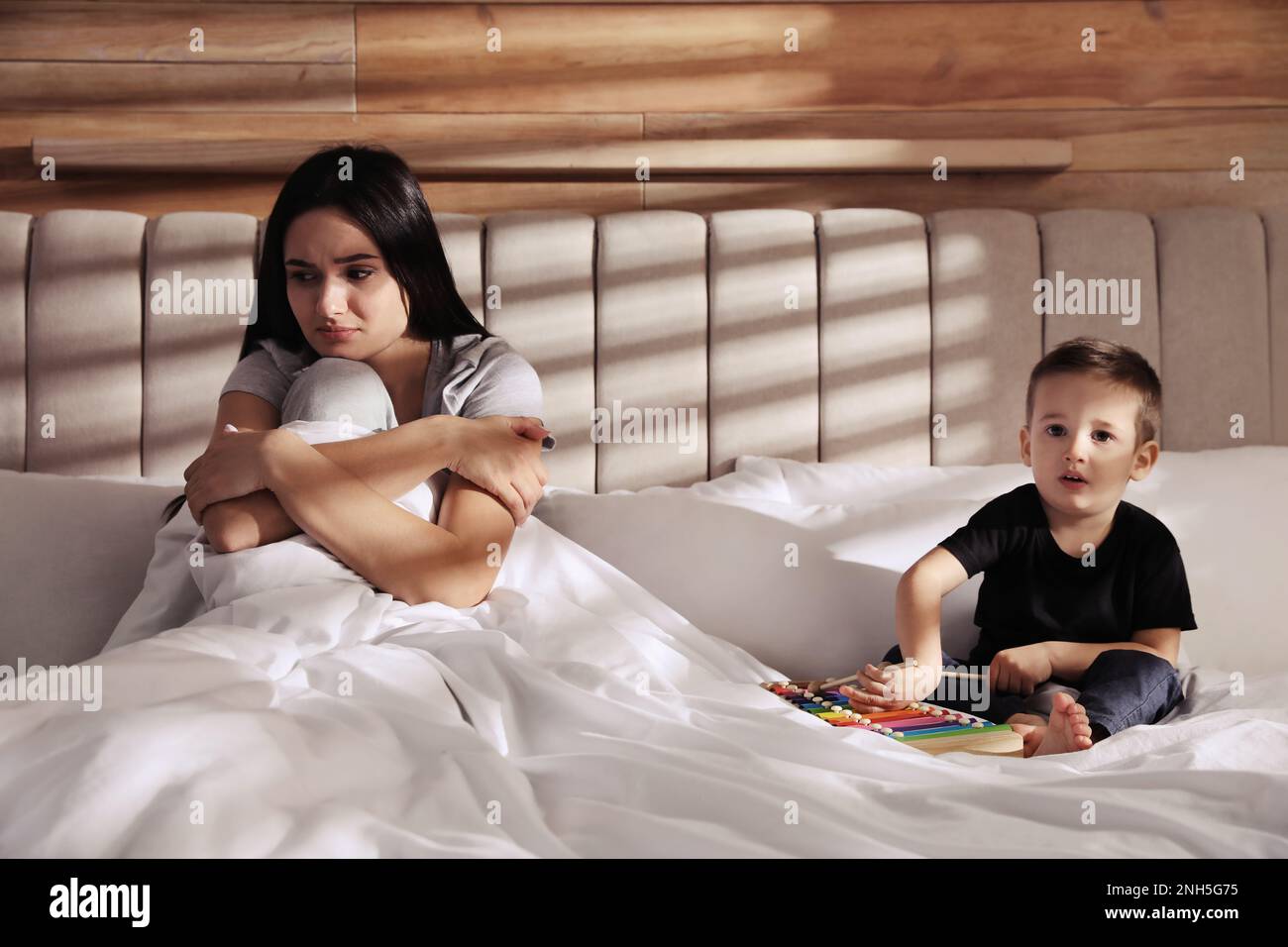 Depressed single mother with child in bed at home Stock Photo - Alamy