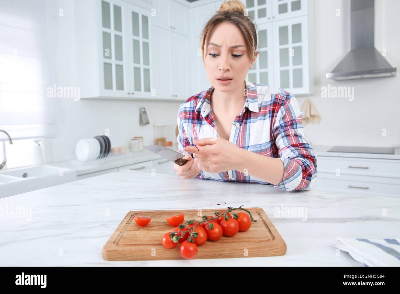 Woman cut finger with knife while cooking in kitchen Stock Photo - Alamy
