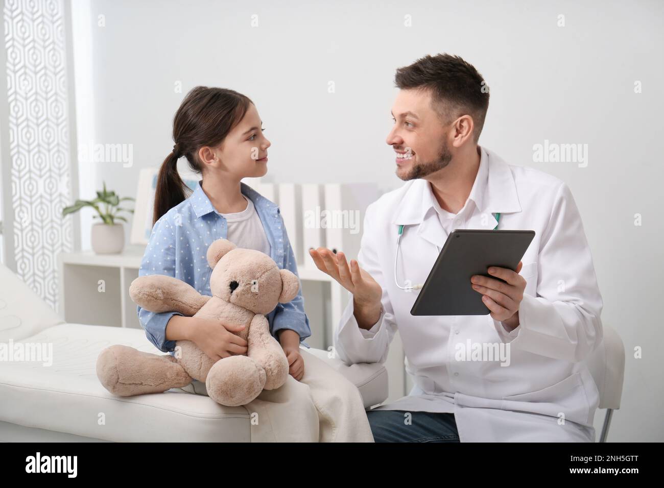 Pediatrician explaining physical examination result to little girl in ...