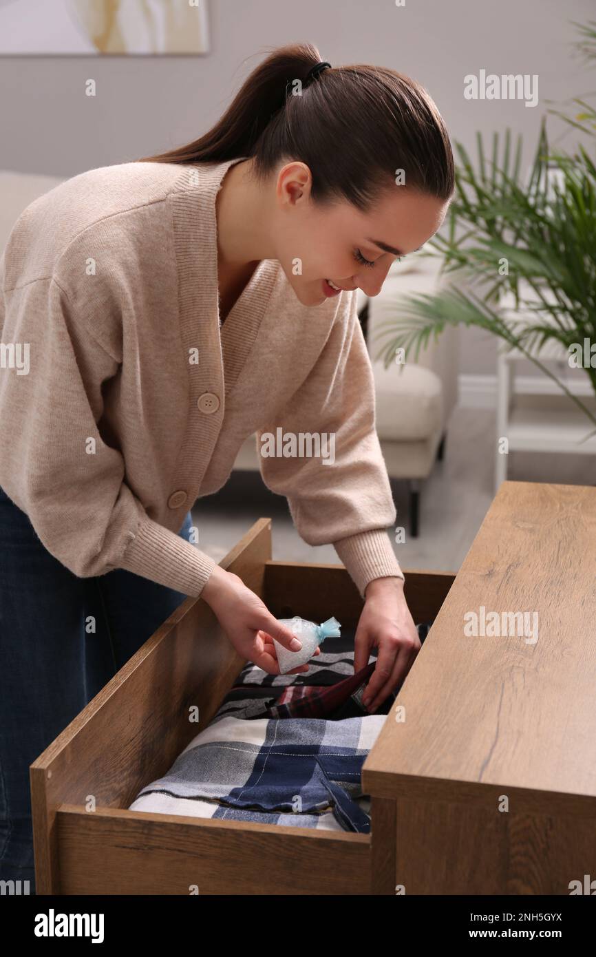 Woman putting scented sachet into drawer with clothes Stock Photo - Alamy