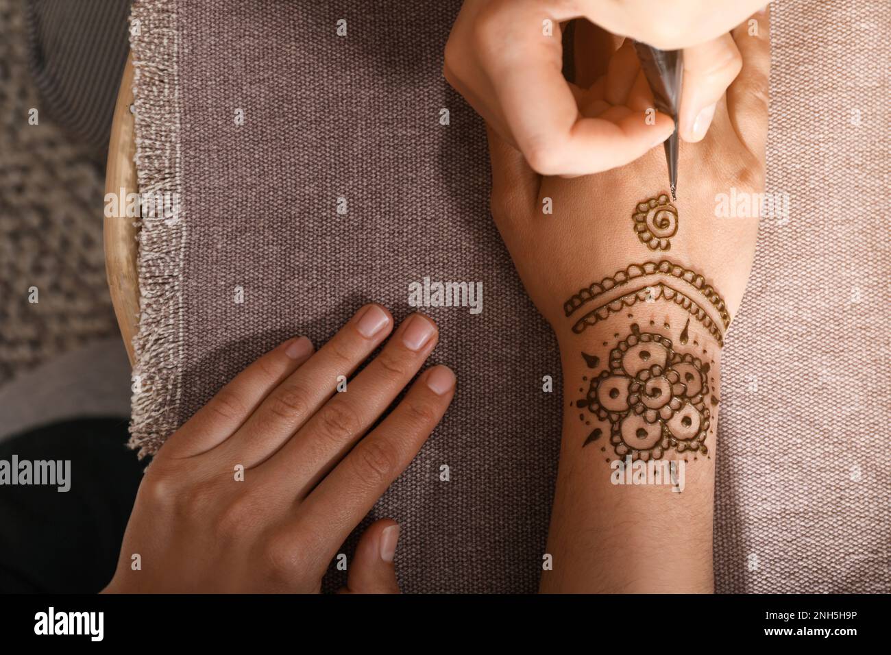 Master making henna tattoo on hand, top view. Traditional mehndi Stock ...
