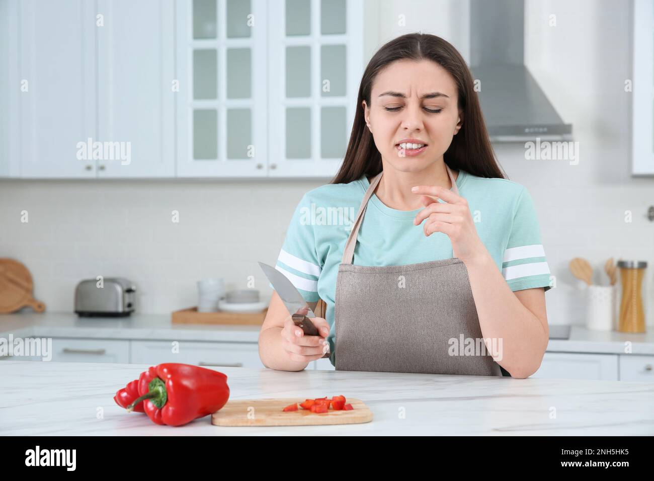 Woman cut finger with knife while cooking in kitchen Stock Photo - Alamy