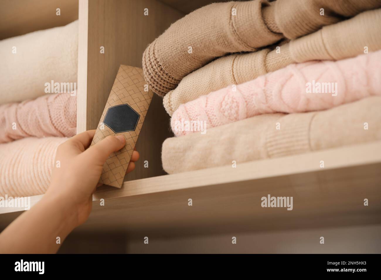 Woman putting scented sachet in wardrobe, closeup Stock Photo - Alamy