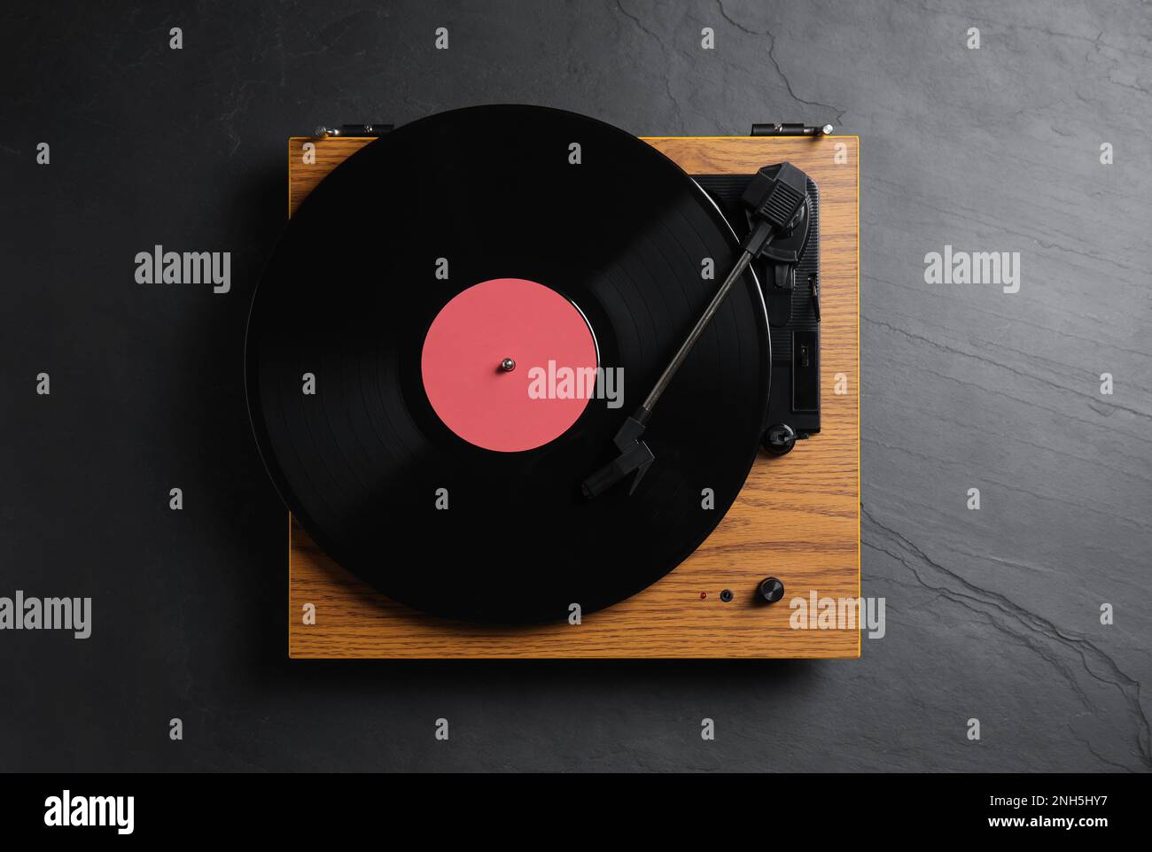 Modern vinyl record player with disc on black background, top view ...