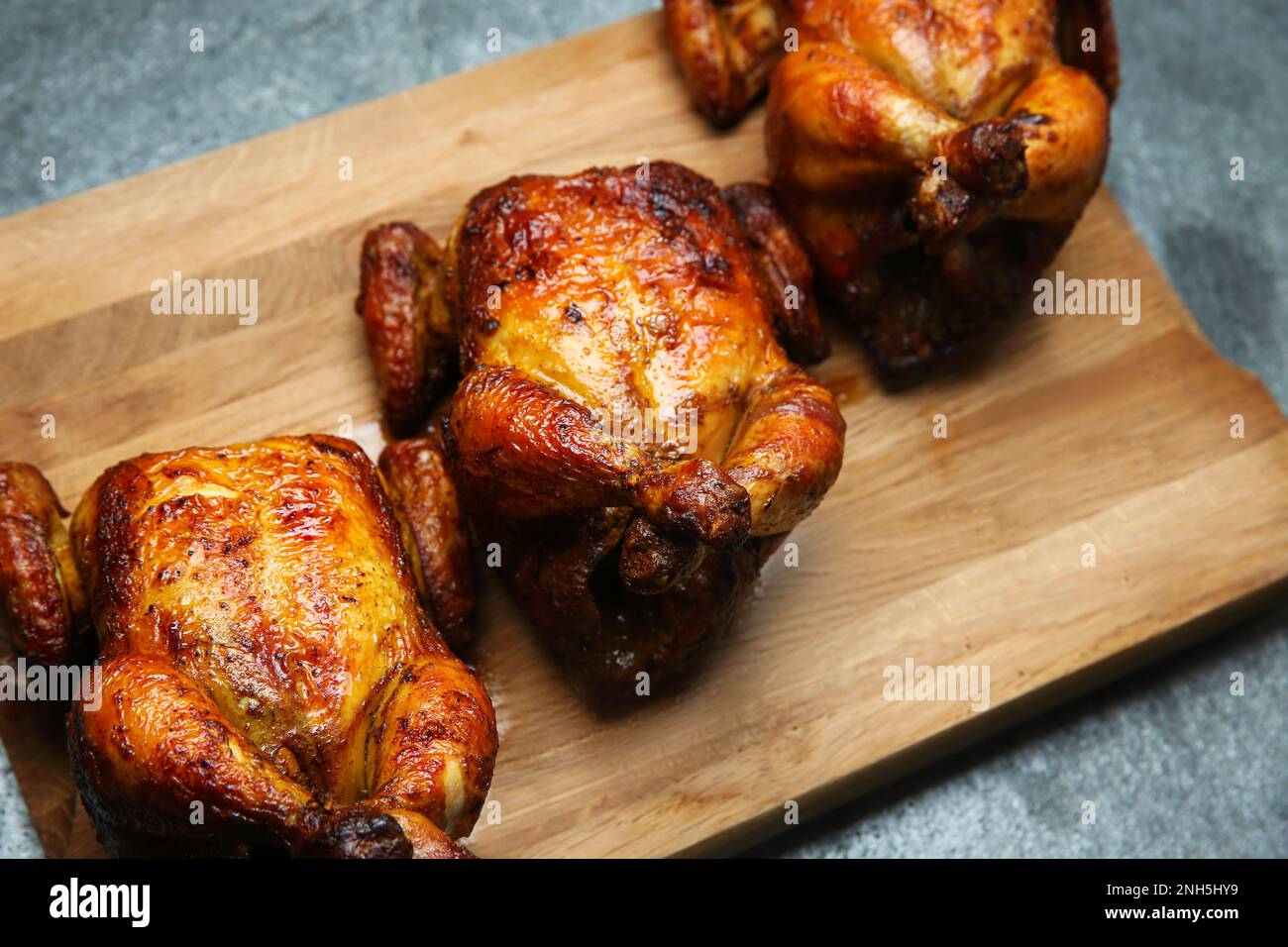 Delicious grilled whole chickens on grey table Stock Photo - Alamy