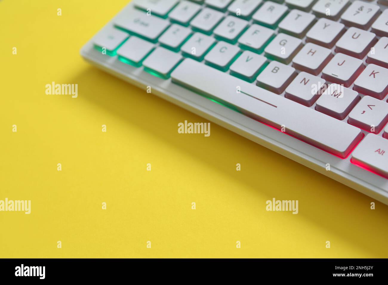 Modern RGB keyboard on yellow background, closeup. Space for text Stock ...