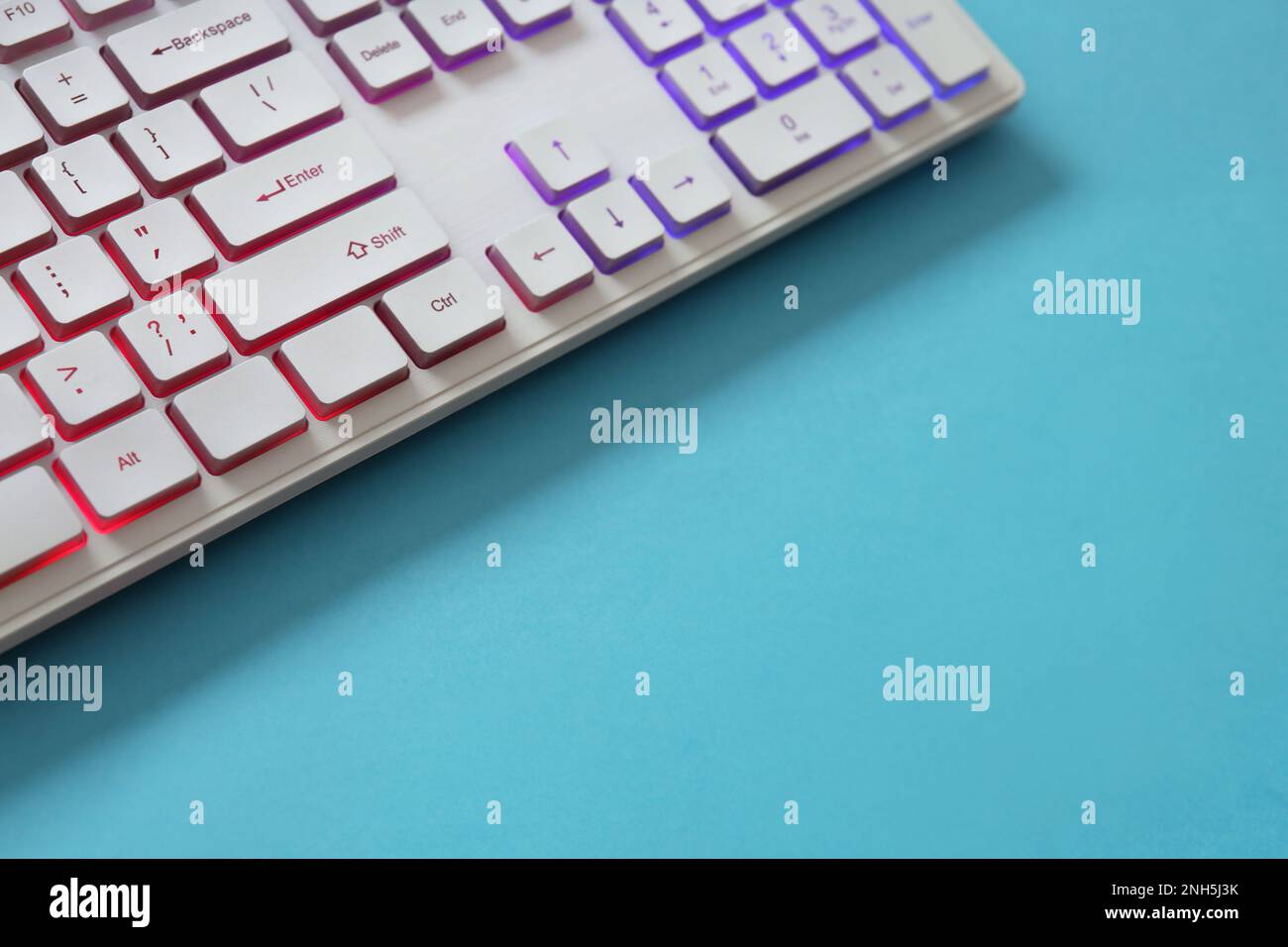 Modern RGB keyboard on turquoise background, closeup. Space for text ...