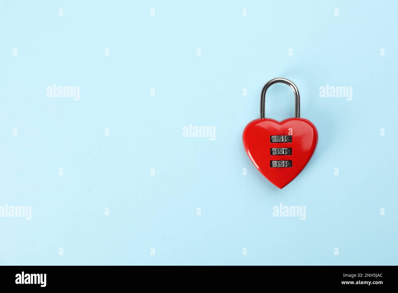 Red heart shaped combination lock on light blue background, top view ...
