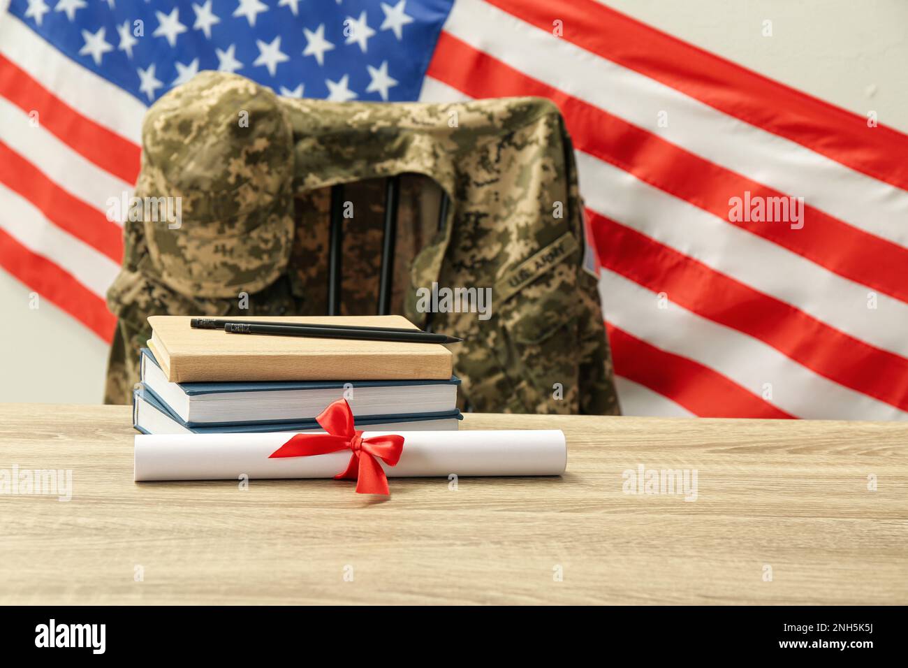 Diploma, books and soldier uniform near flag of United States. Military ...