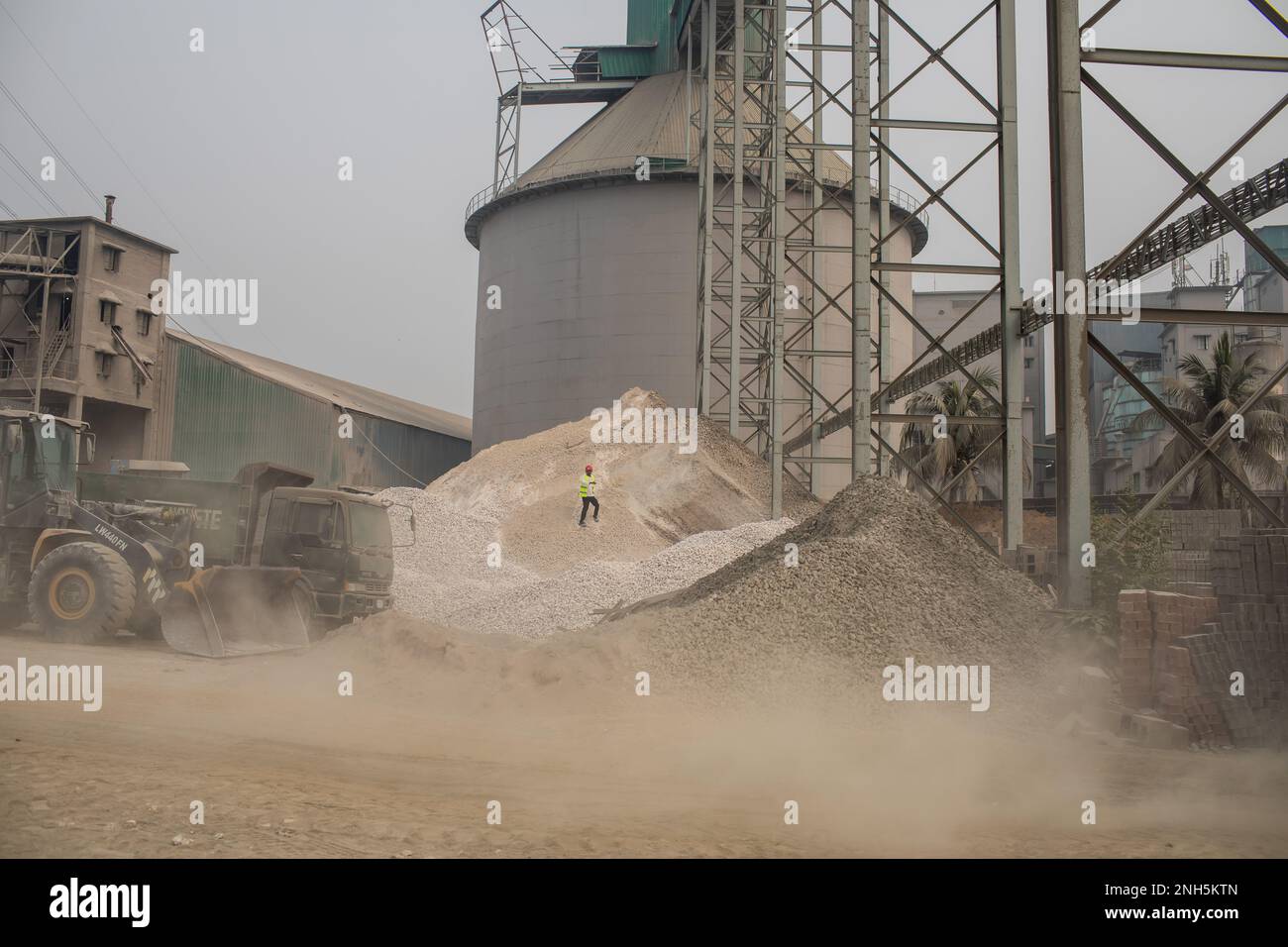 A worker walks along the territory of the Mir cement plant. Mir Cement ...