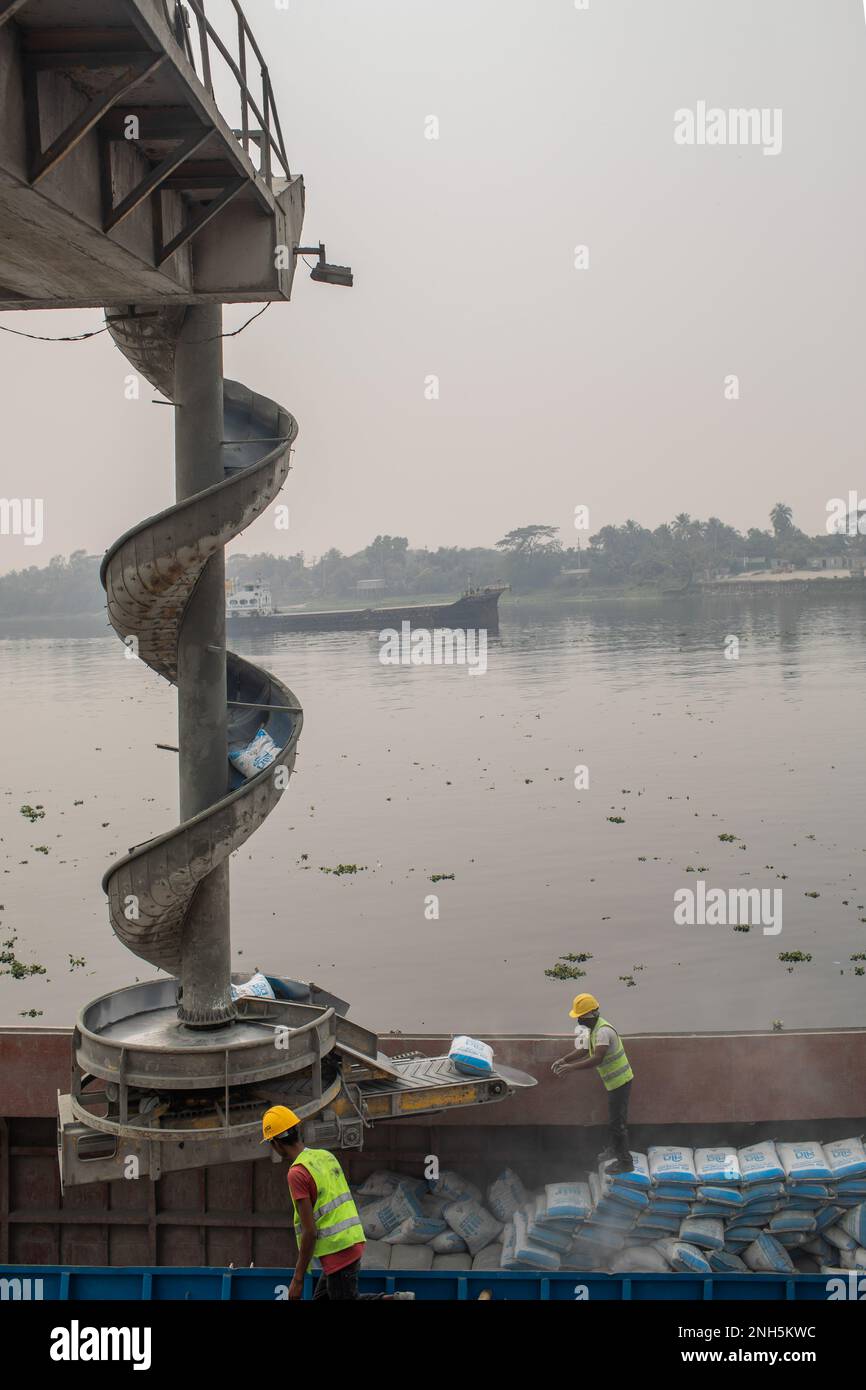 Workers collect cement bags at the Mir cement plant. Mir Cement Ltd is ...