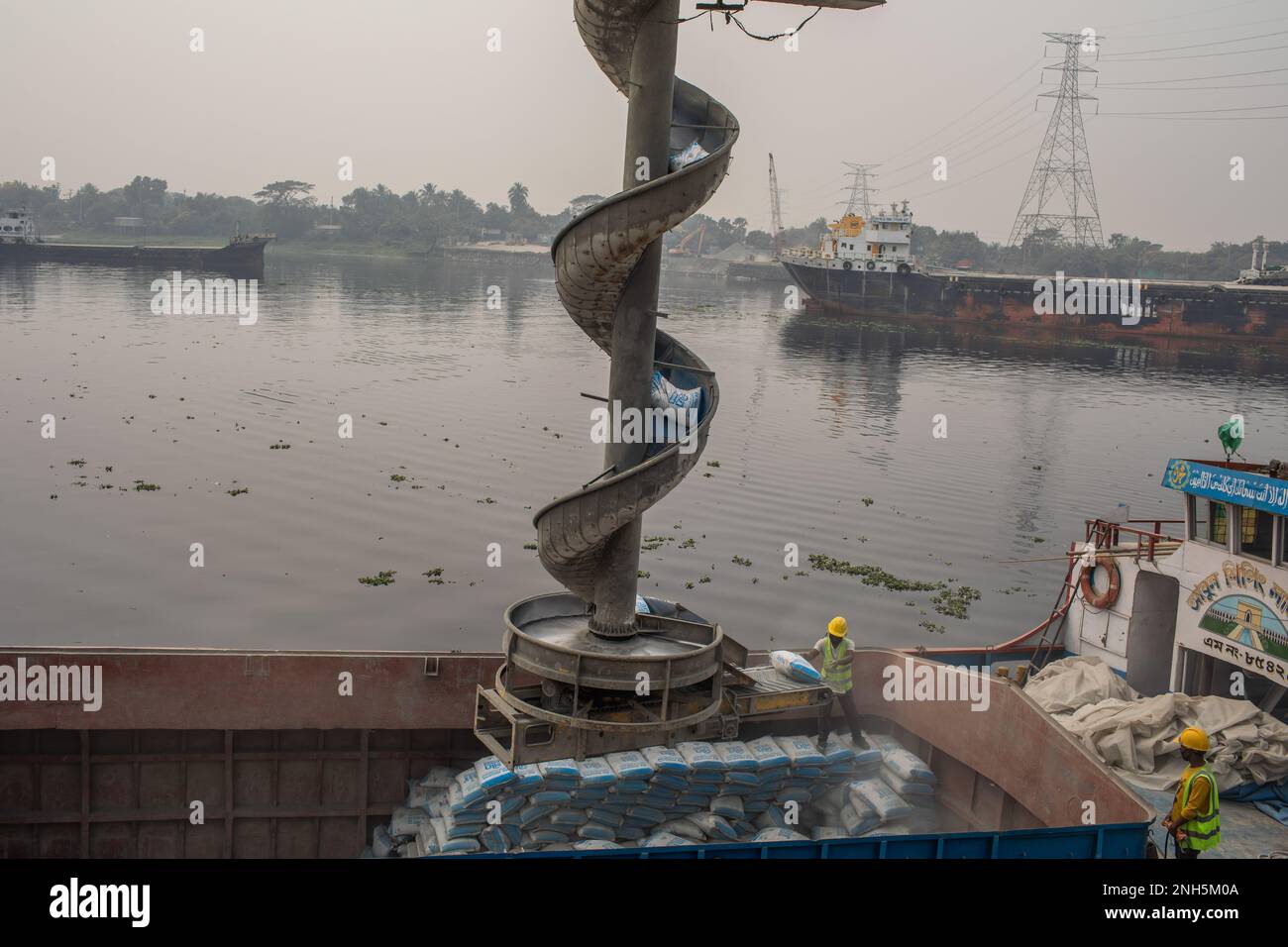 Workers collect cement bags at the Mir cement plant. Mir Cement Ltd is ...