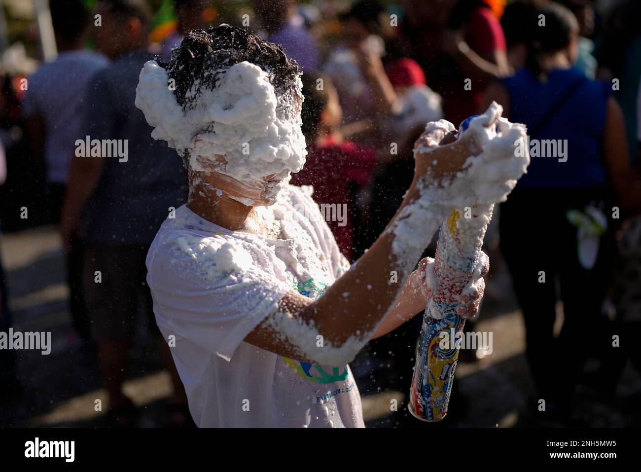 A boy with his face covered with foam plays during carnival ...