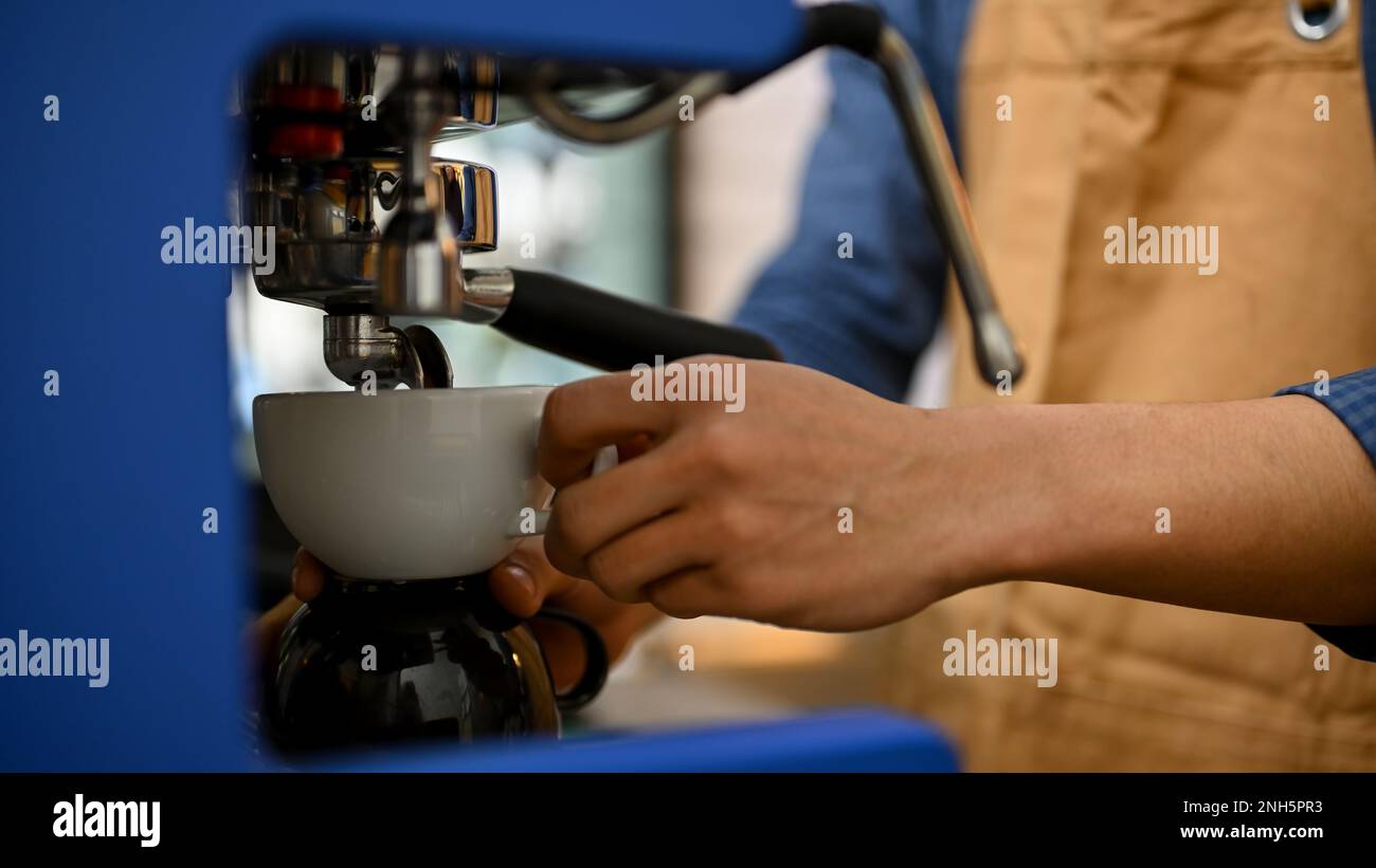 A male barista making coffee with coffee espresso machine, preparing ...