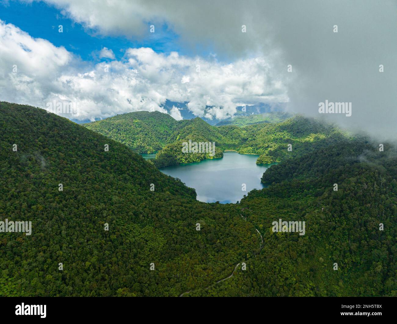 Mountain lake surrounded by green forest. Balinsasayao Twin Lakes ...