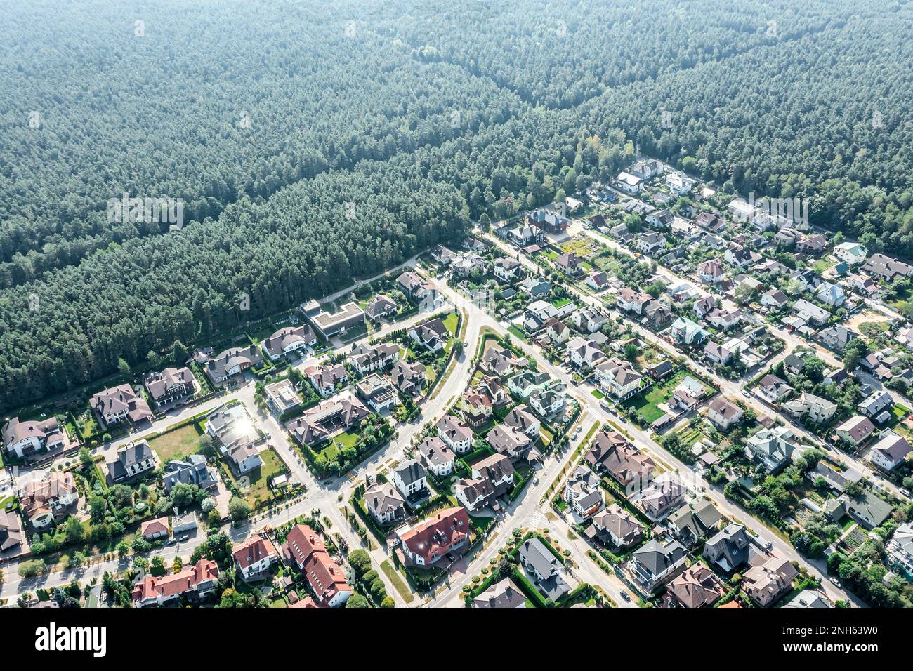 aerial view of suburban neighborhood near green forest in a sunny ...
