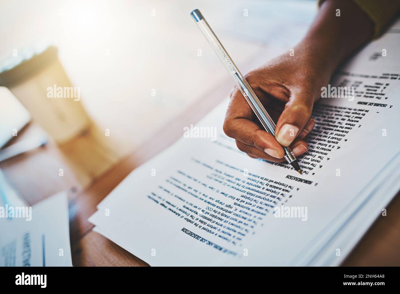 Combing through the fine print. a businesswoman completing paperwork at ...
