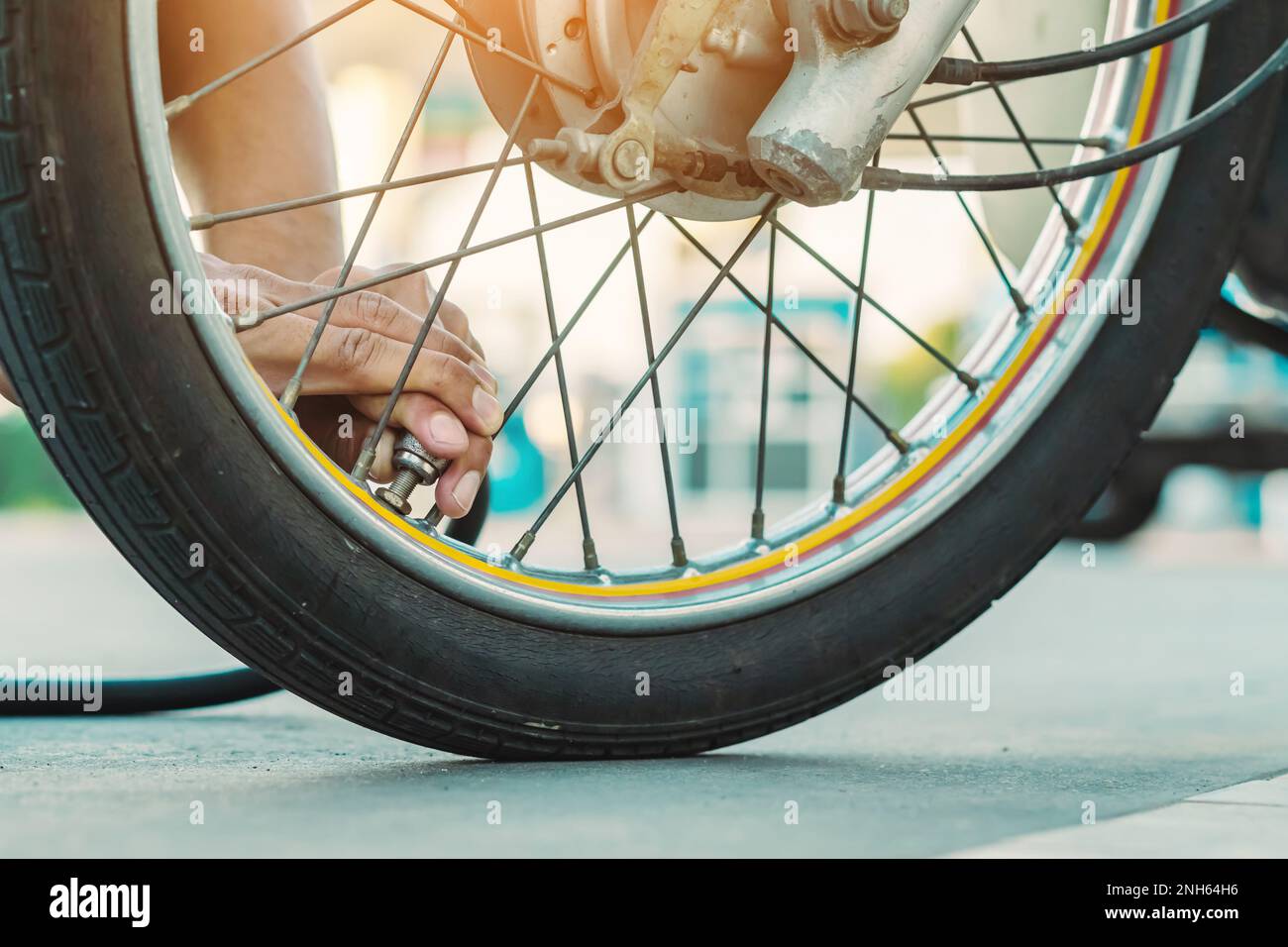 Hands of man check inflator pressure and inflates a tire on motorcycle ...