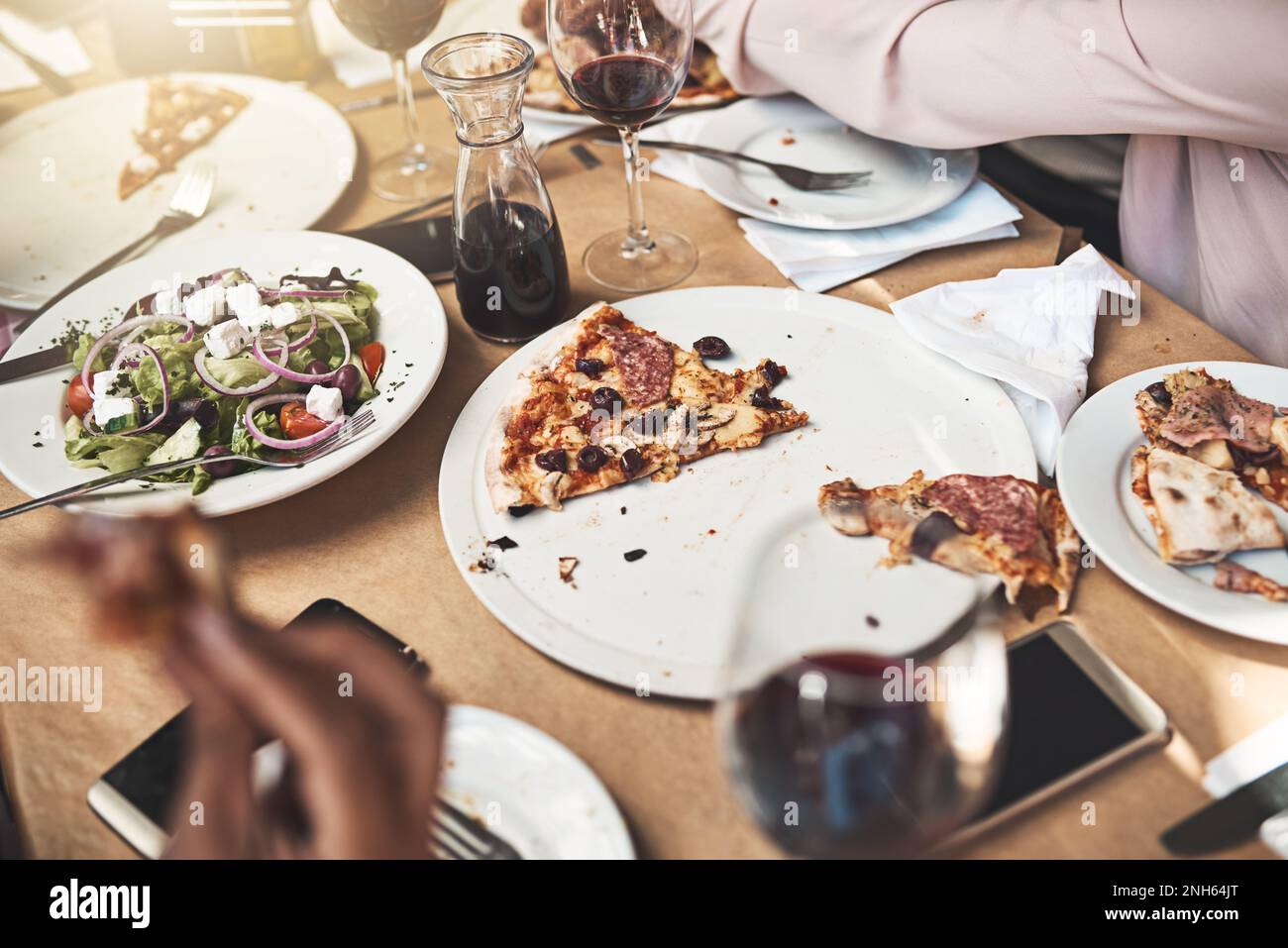 That pizza got eaten quickly. a group of unrecognizable people eating ...