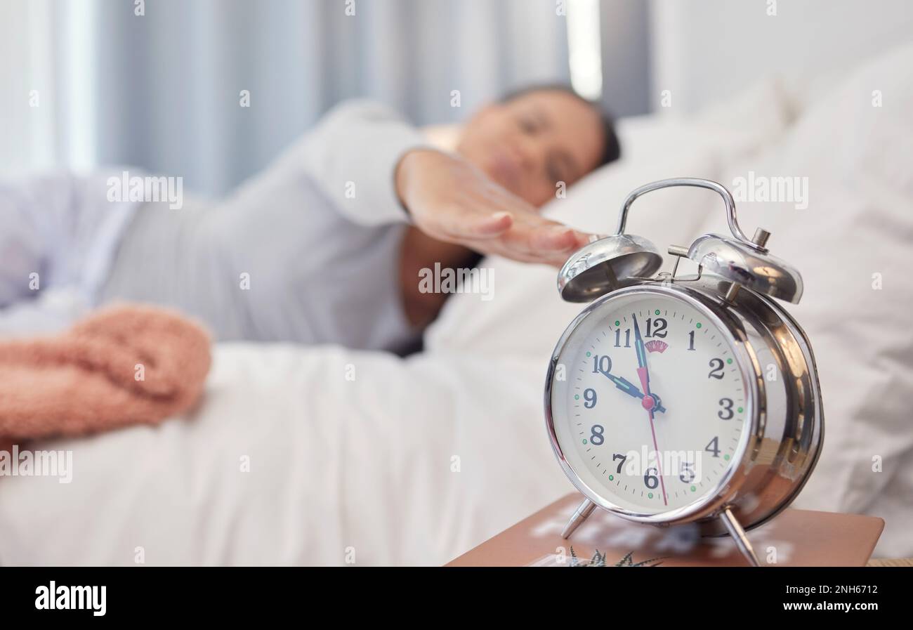 Woman, bed and alarm clock with snooze, sleeping and tired in morning ...