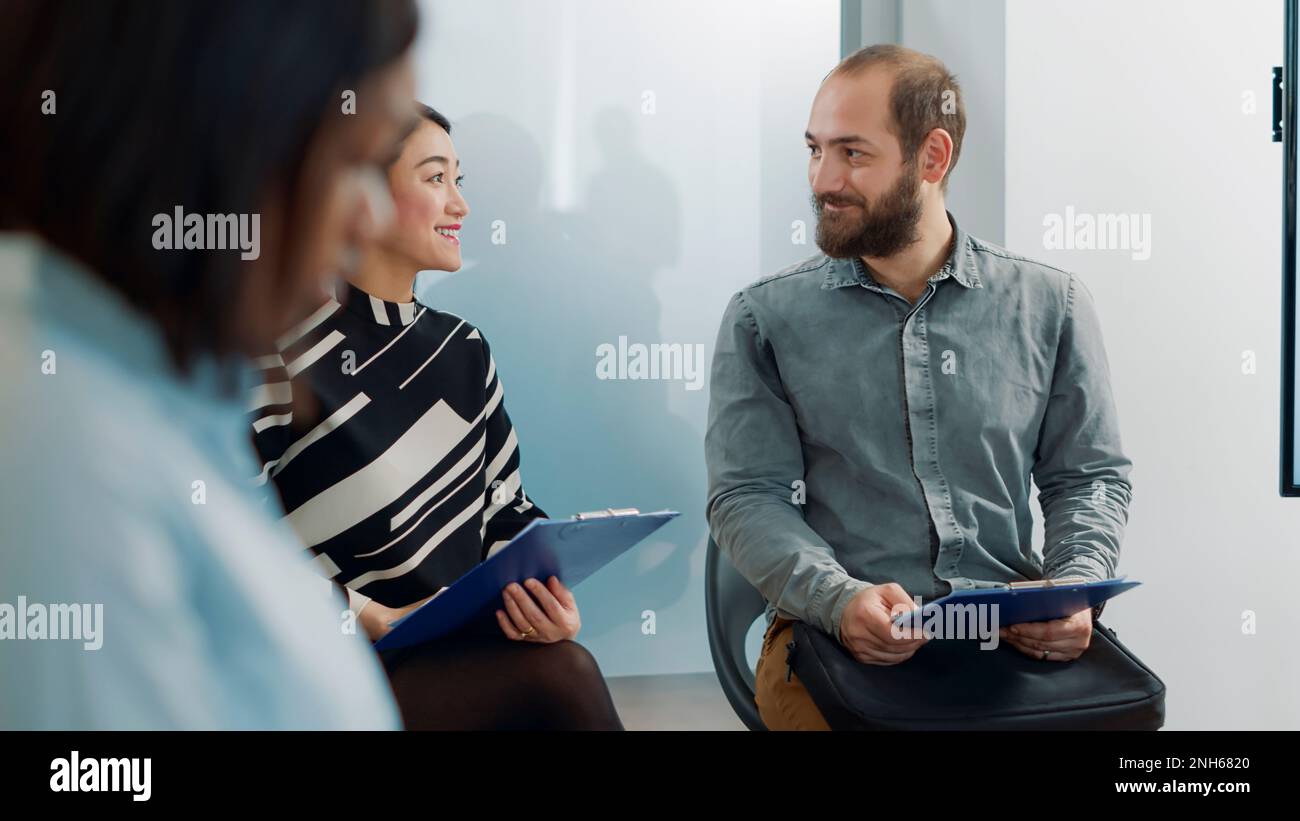 Man and asian woman having conversation about work offer, sitting in ...