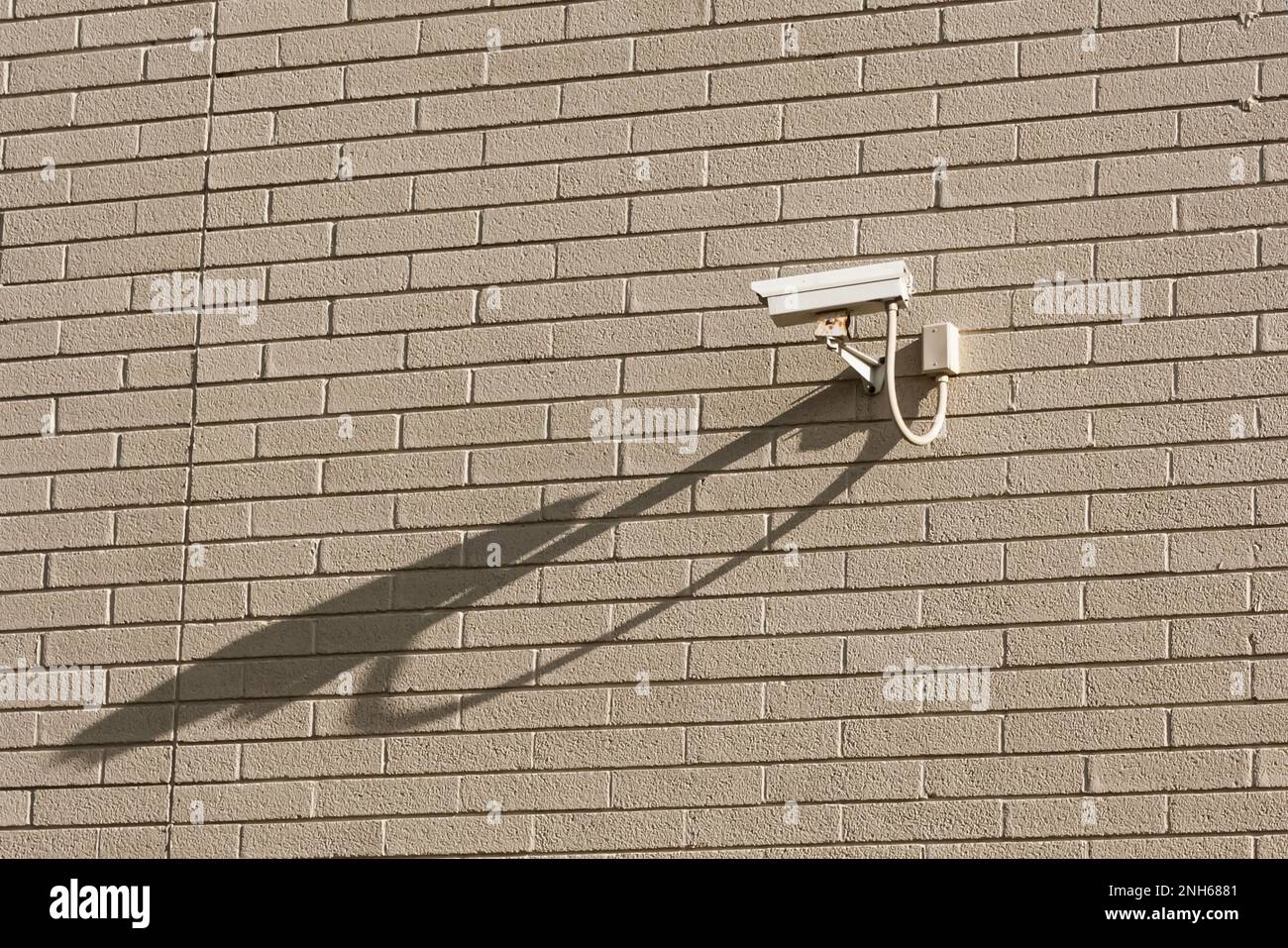 A surveillance camera casting a long shadow Stock Photo - Alamy