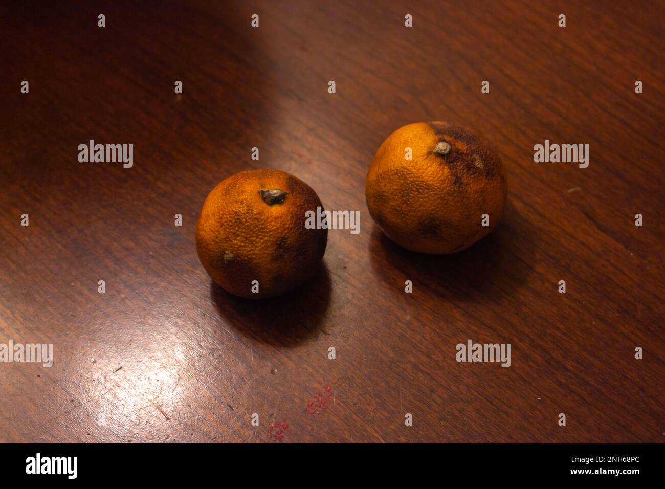 Mandarin oranges on wooden table. Orange in image have gone a little ...