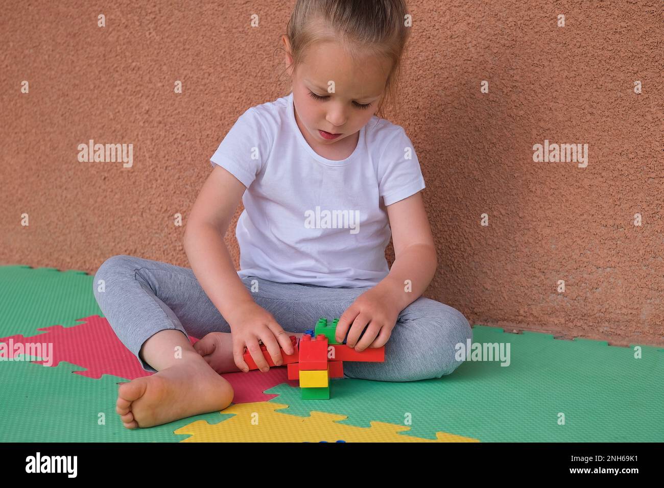 concentrated little girl playing building blocks lego colorful ...